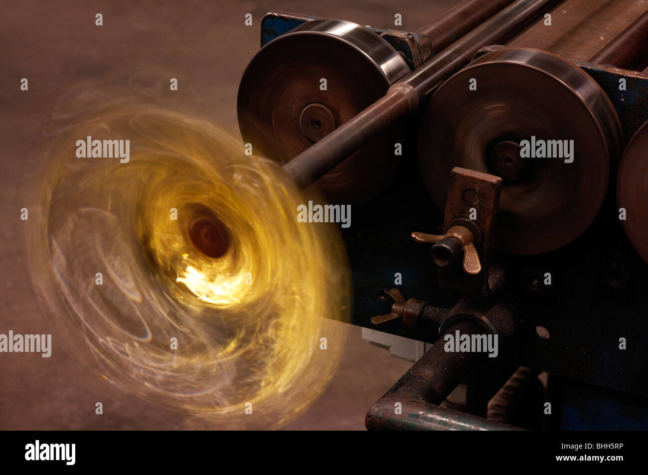 hot glass rotating on a turning machine during manufacture Stock Photo ...