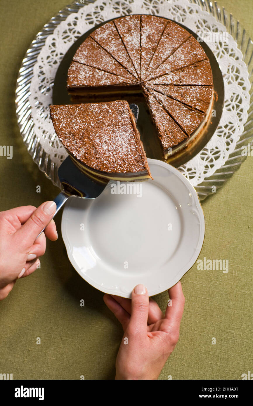 Hand taking a big part of a chocolate cake Stock Photo - Alamy