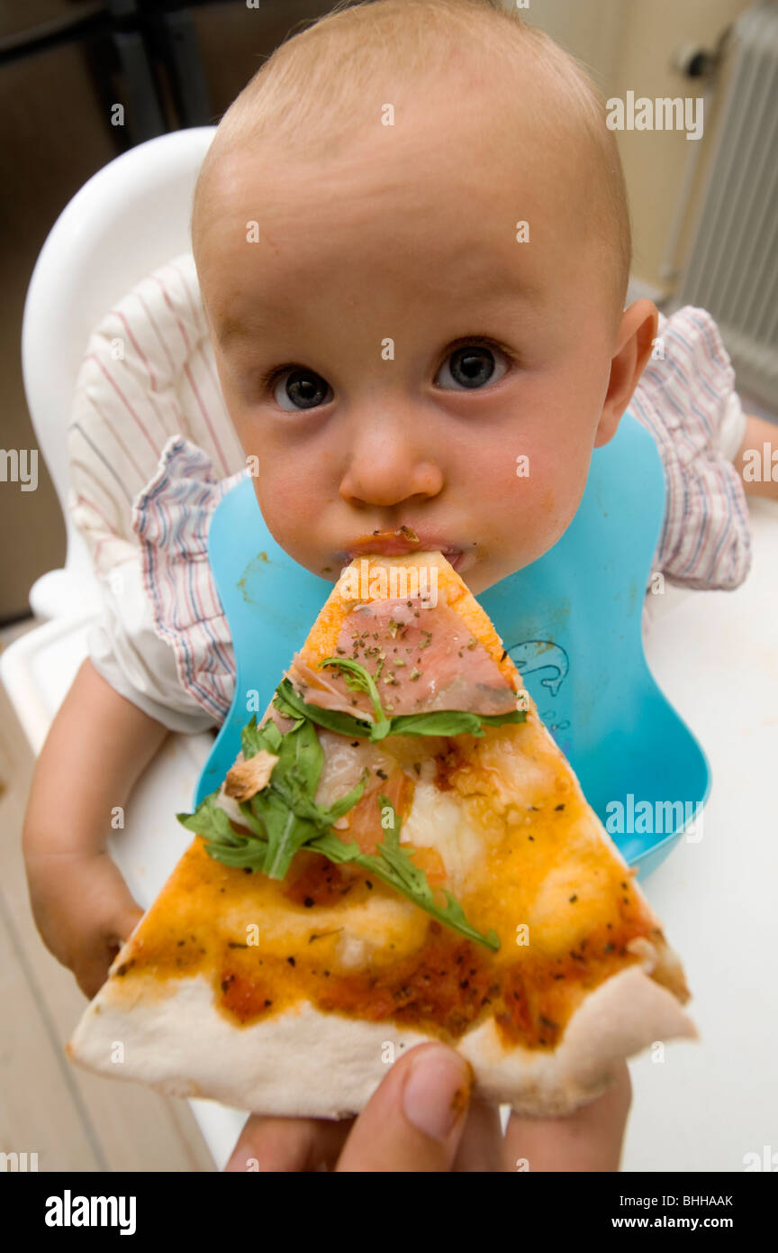 A baby eating pizza, Sweden Stock Photo - Alamy
