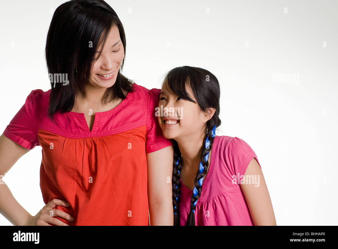 Woman and girl standing side by side Stock Photo - Alamy