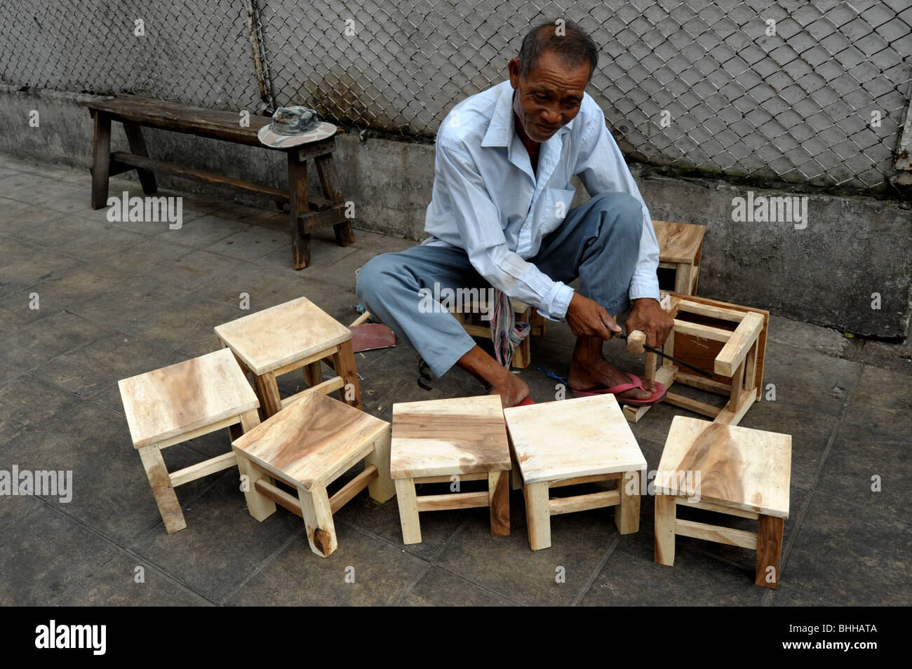 old man in klong toei market making stools , klong toei , bangkok ...