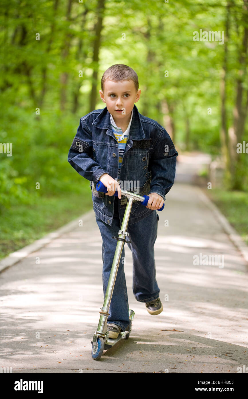 Cute kid riding a scooter in a park Stock Photo - Alamy