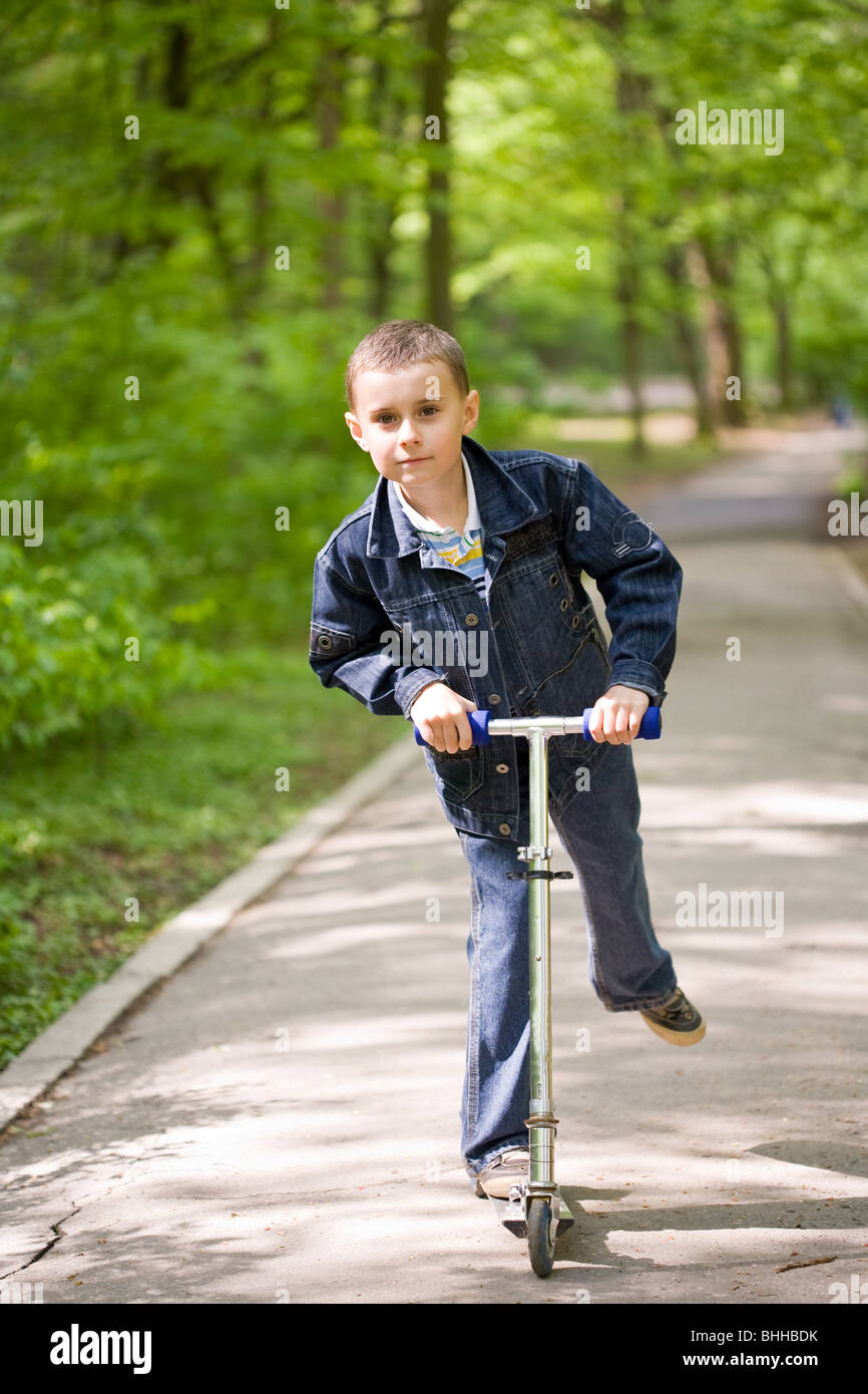 Cute kid riding a scooter in a park Stock Photo - Alamy