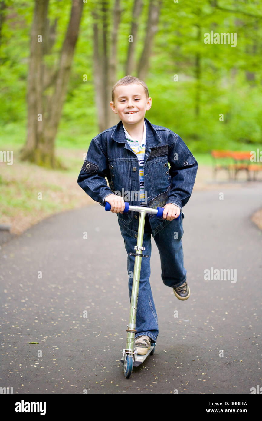 Cute kid riding a scooter in a park Stock Photo - Alamy