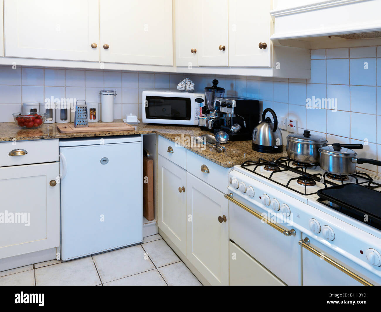 A Kitchen with Metal Objects in View, Fridge, Oven, Utensils, Cheese ...
