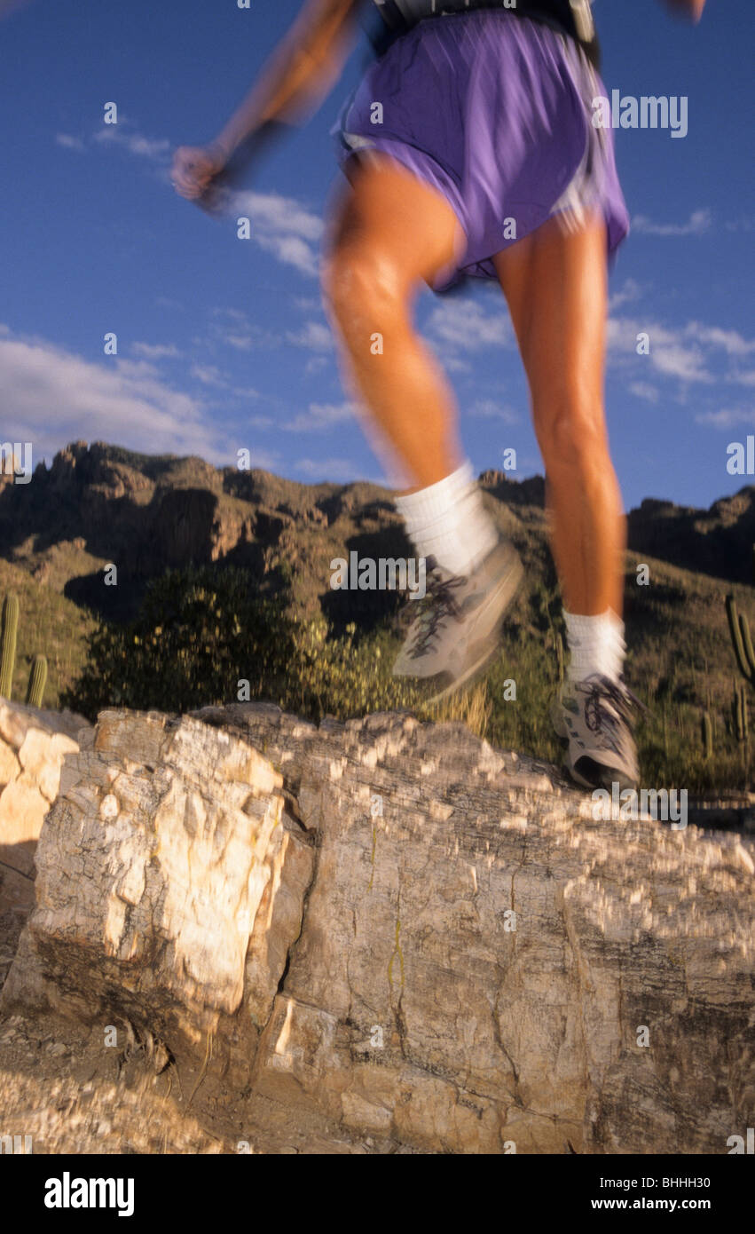 Woman jumping off rocks Stock Photo - Alamy