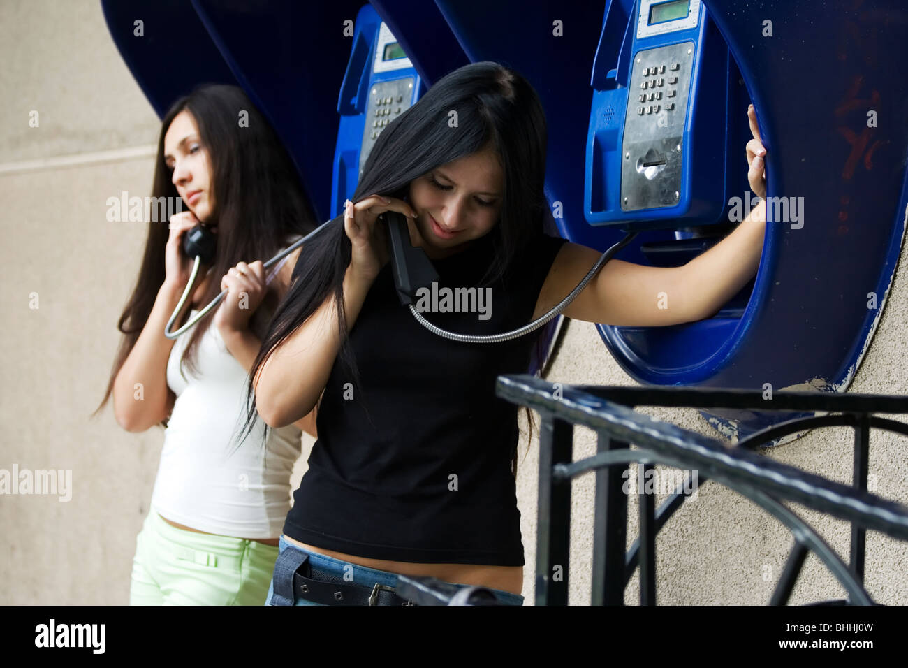 Two young women on the phone Stock Photo - Alamy