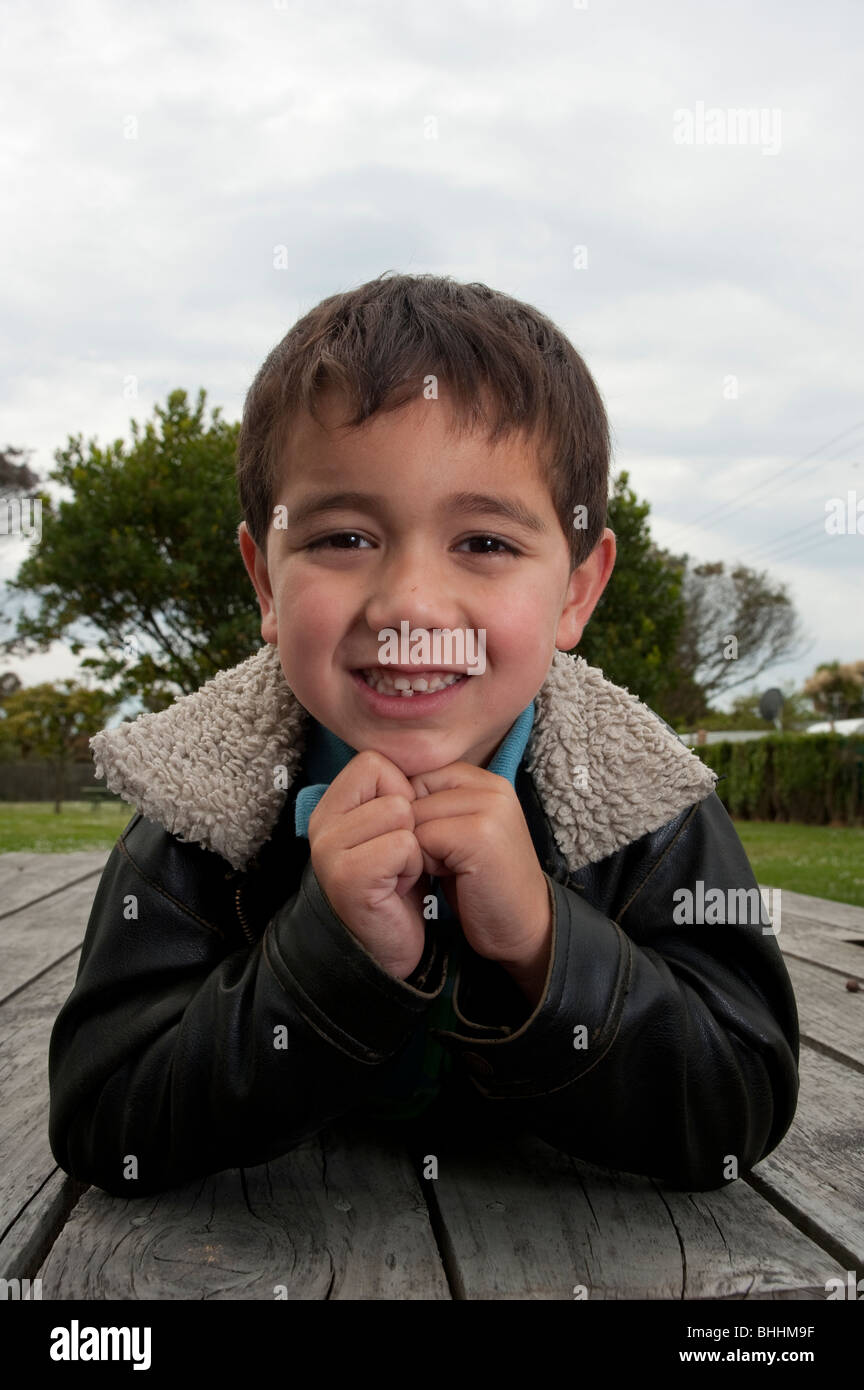 portrait of little Pacific Islander boy chin on hands in park Stock ...