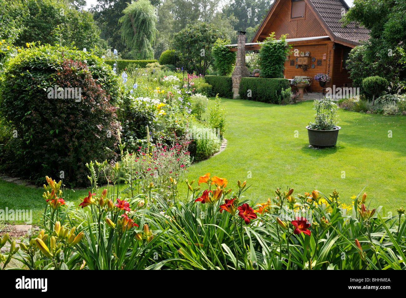 Wooden house with lawn and perennial beds. Design: Marianne and Detlef ...
