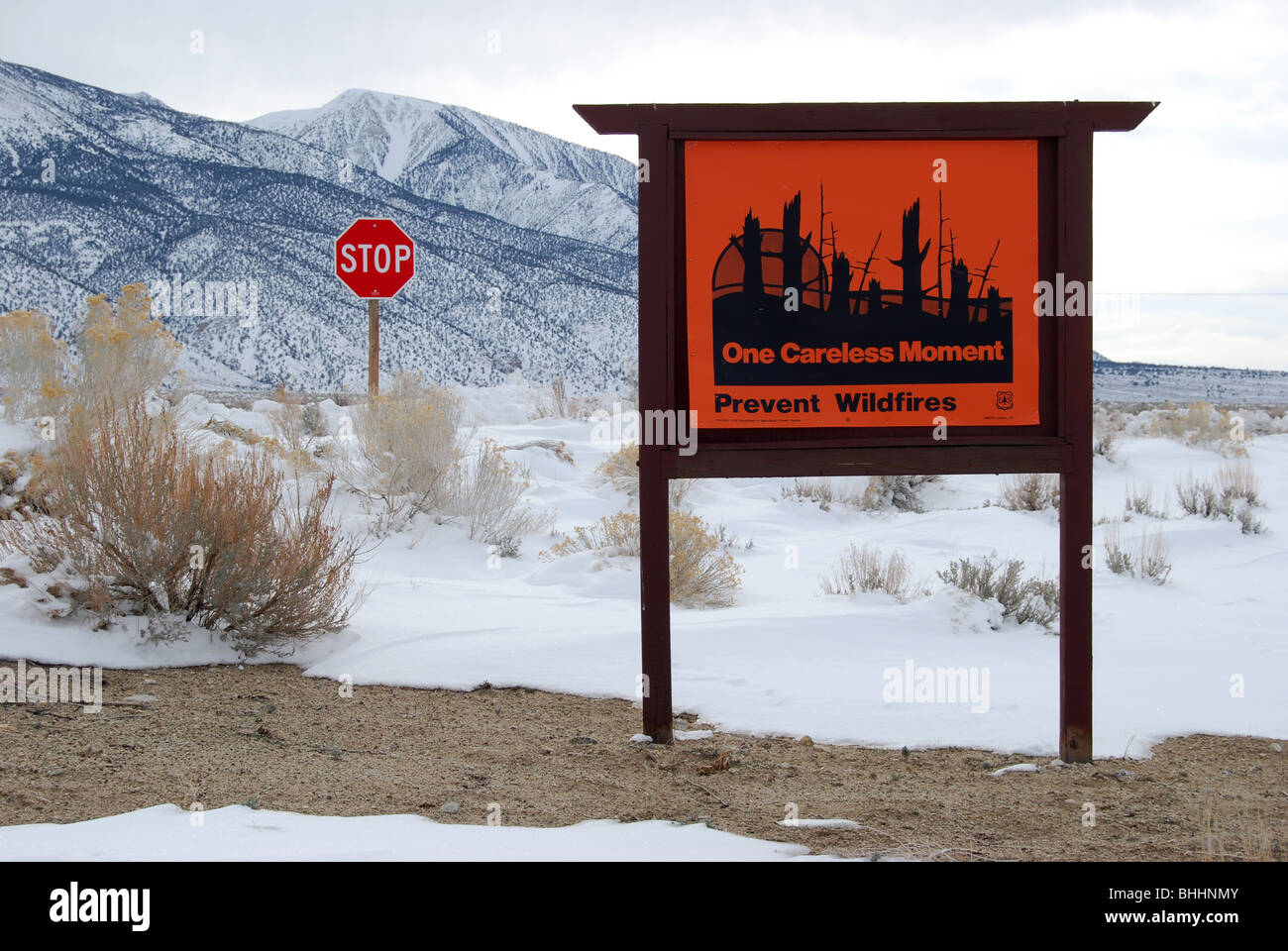 prevent wildfire sign surrounded by snow and stop sign in background ...