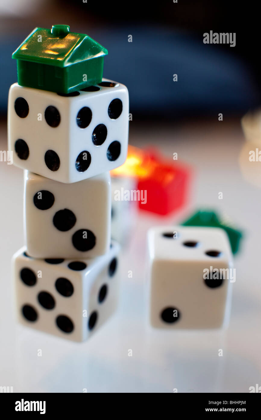Stacked dice with Monopoly house Stock Photo - Alamy