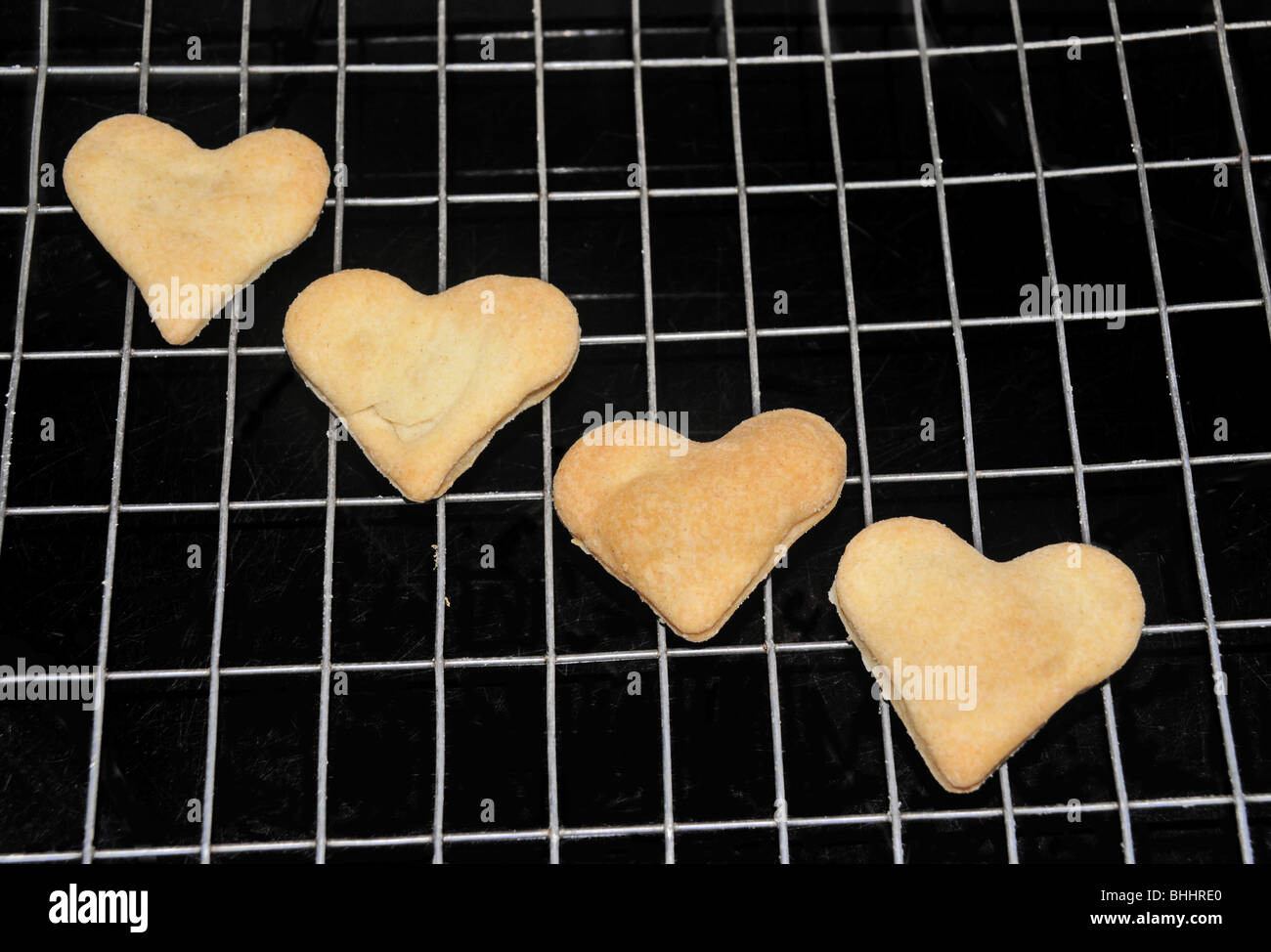 A cooling rack with heart shaped biscuits Stock Photo - Alamy