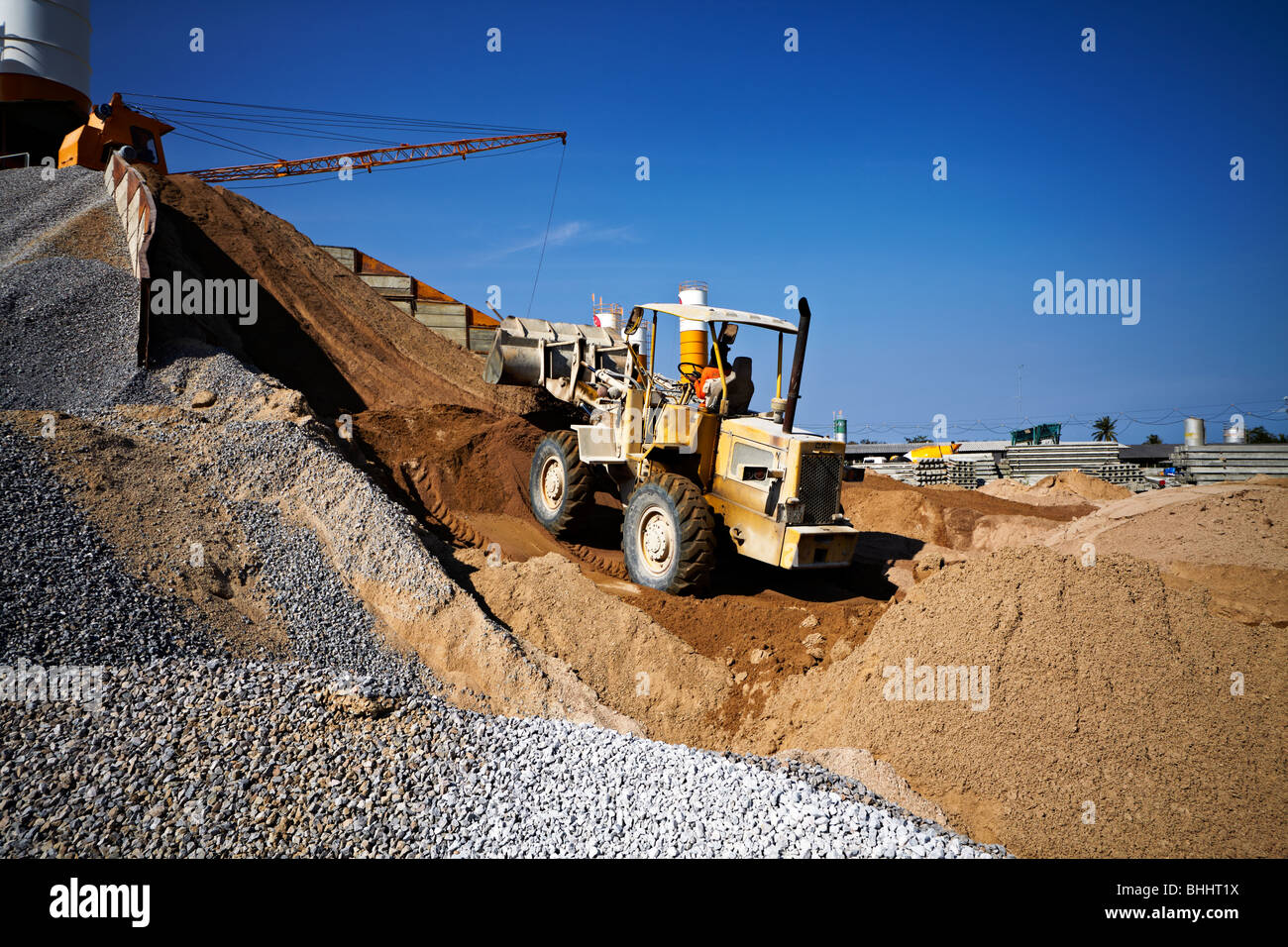 Caterpillar tractor building site. Thai cement production plant with ...