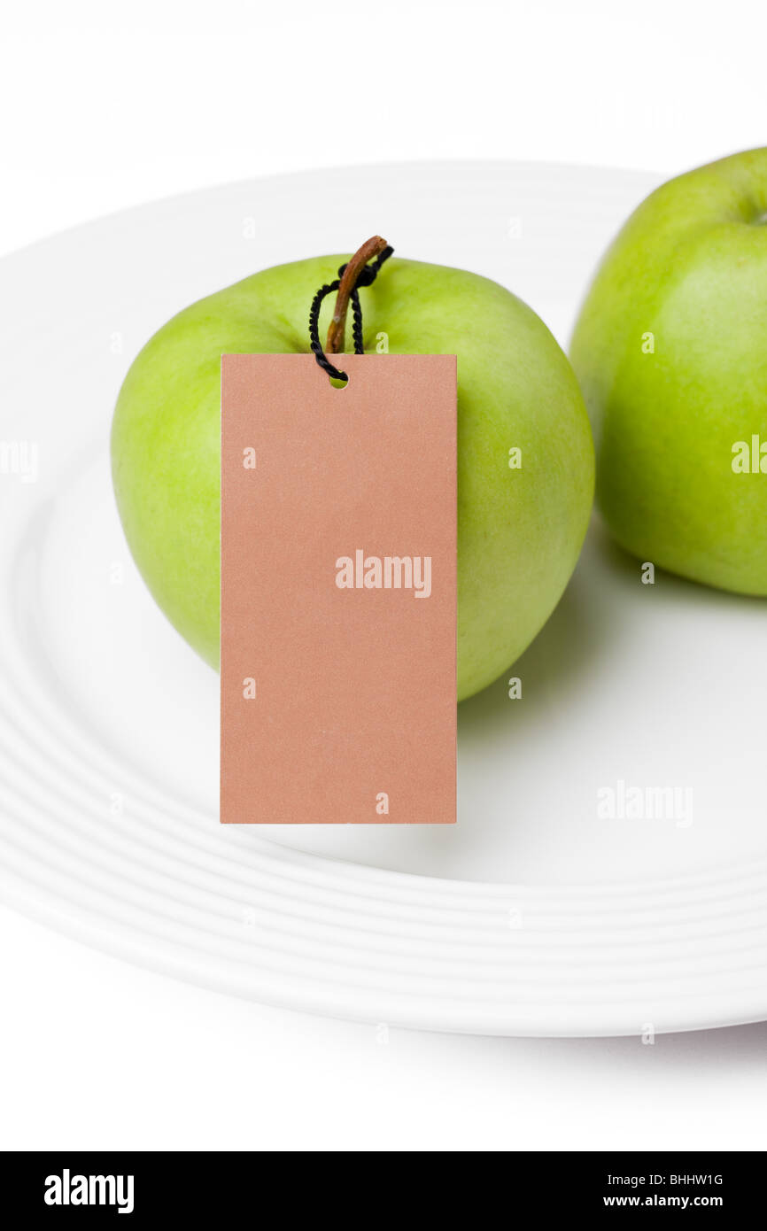 green apples with label on white plate Stock Photo - Alamy