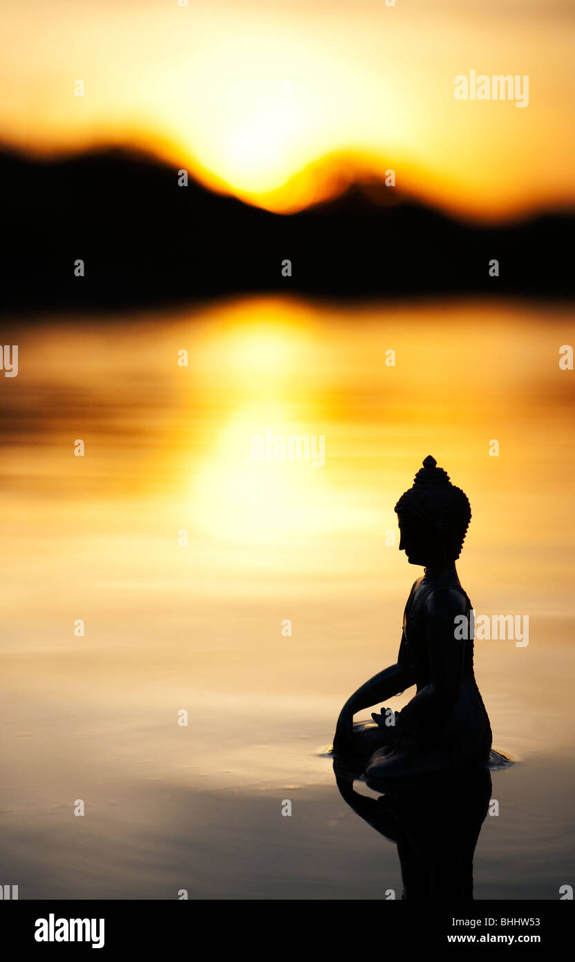 Silhouette of Buddha statue floating on calm still water surface at ...