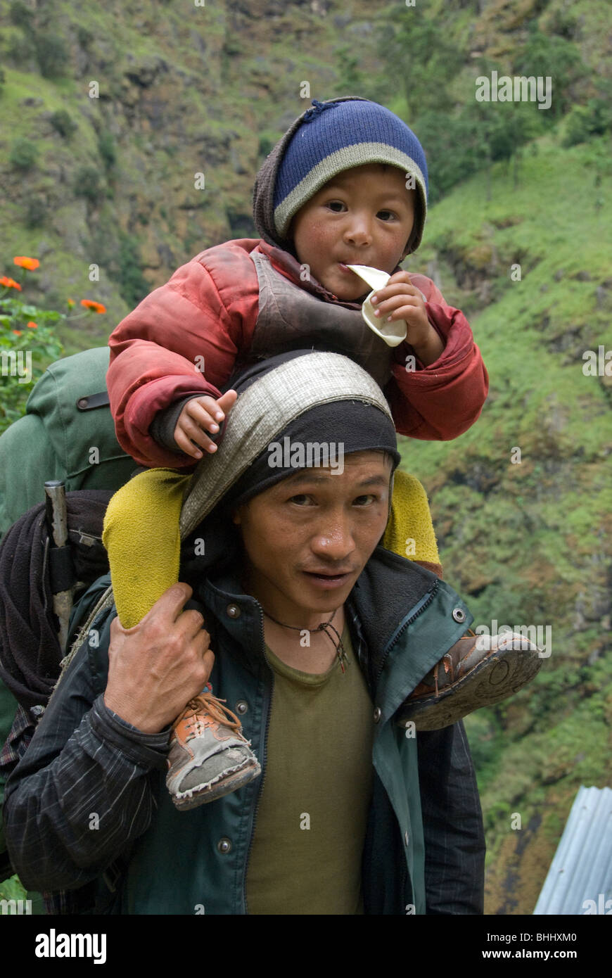 Man carrying child on his shoulders, Chyamche, Nepal Stock Photo - Alamy