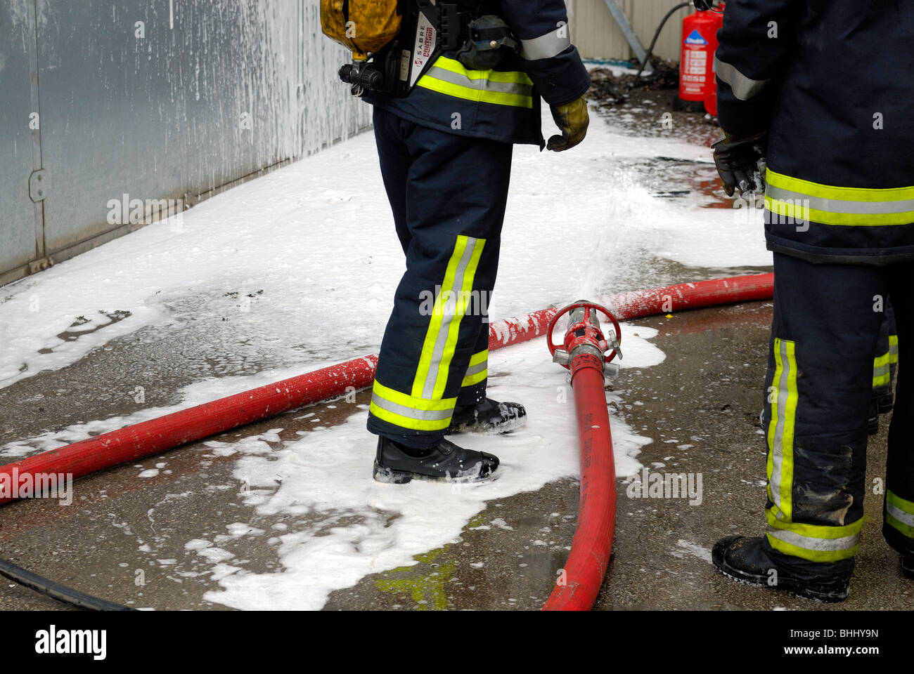 firemen with foam branches and hoses Stock Photo - Alamy