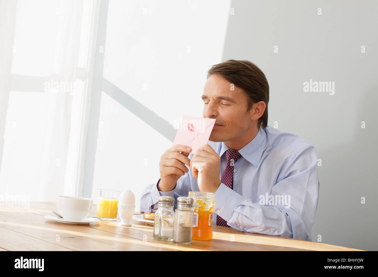 man taking a smell at a love letter Stock Photo - Alamy