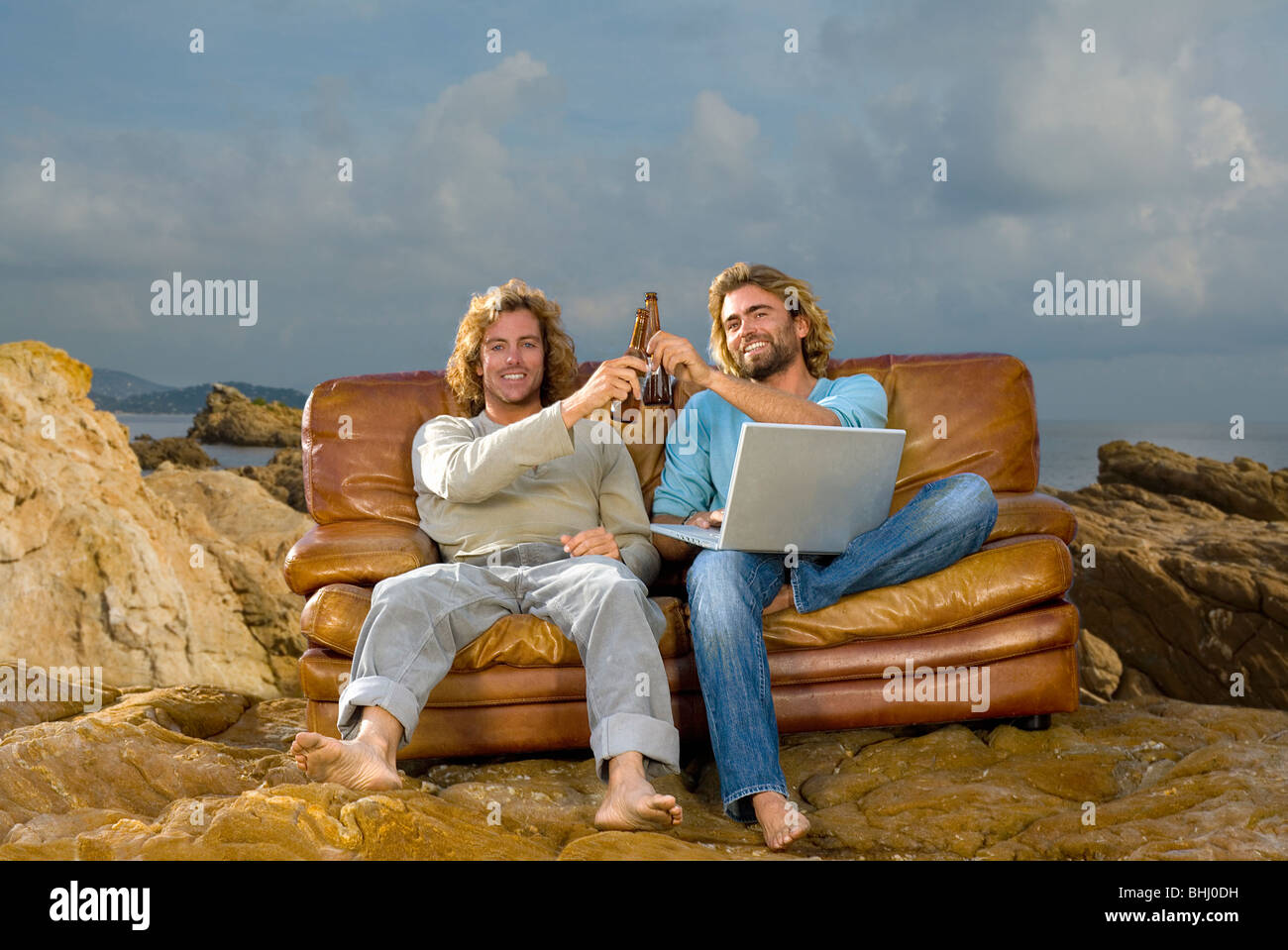 young men with laptop and beer, couch at Stock Photo - Alamy