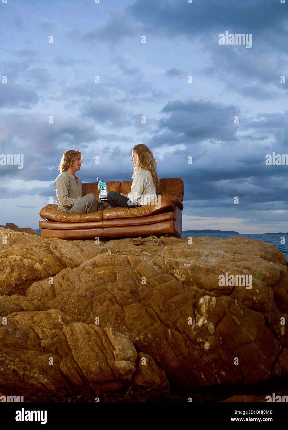 couple. with laptop on couch at beach Stock Photo - Alamy