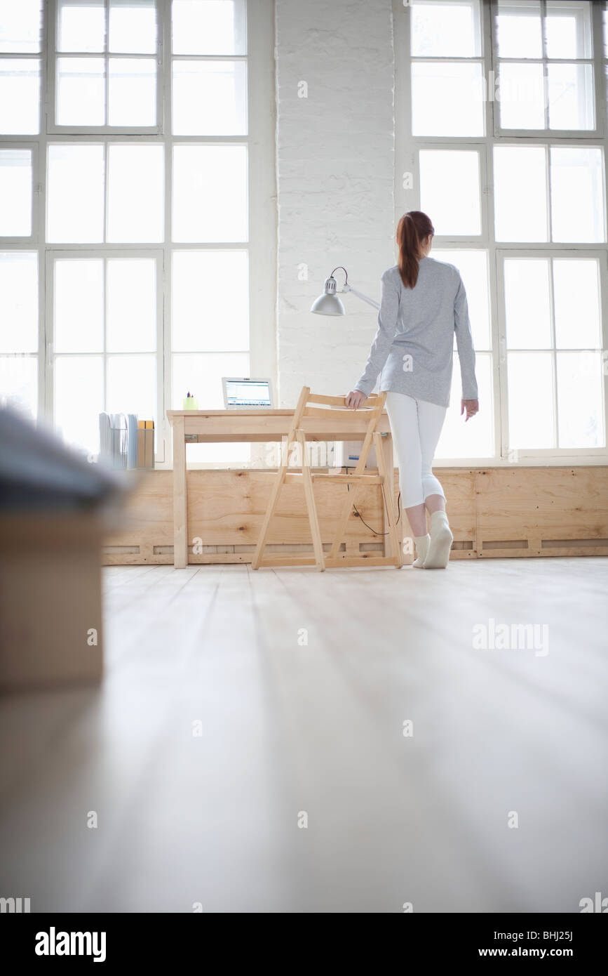 Woman walks across loft apartment Stock Photo - Alamy