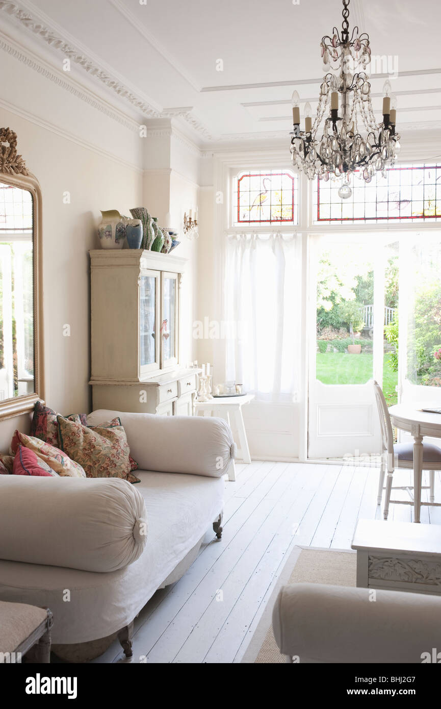 Daybed with cushions and glass chandelier in white home interior Stock ...