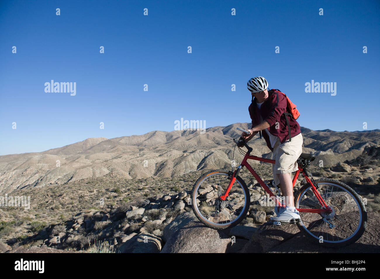Young man waits with mountain bike looking back over his shoulder Stock ...