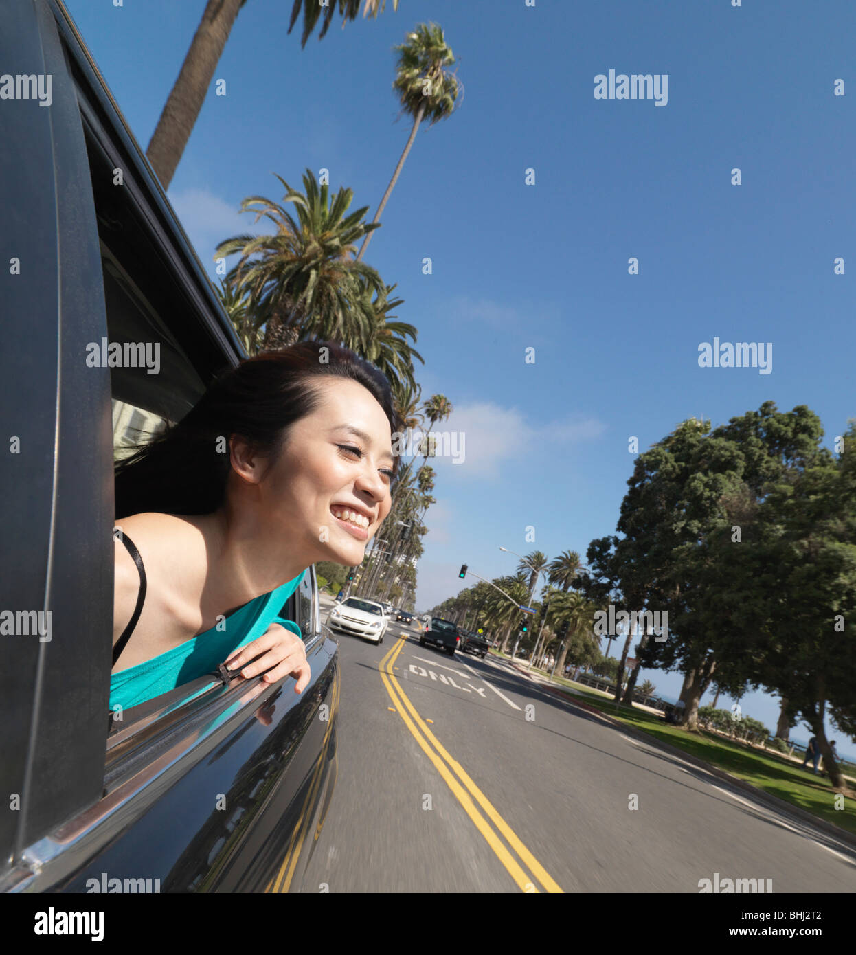Young woman leaning out of car window Stock Photo - Alamy