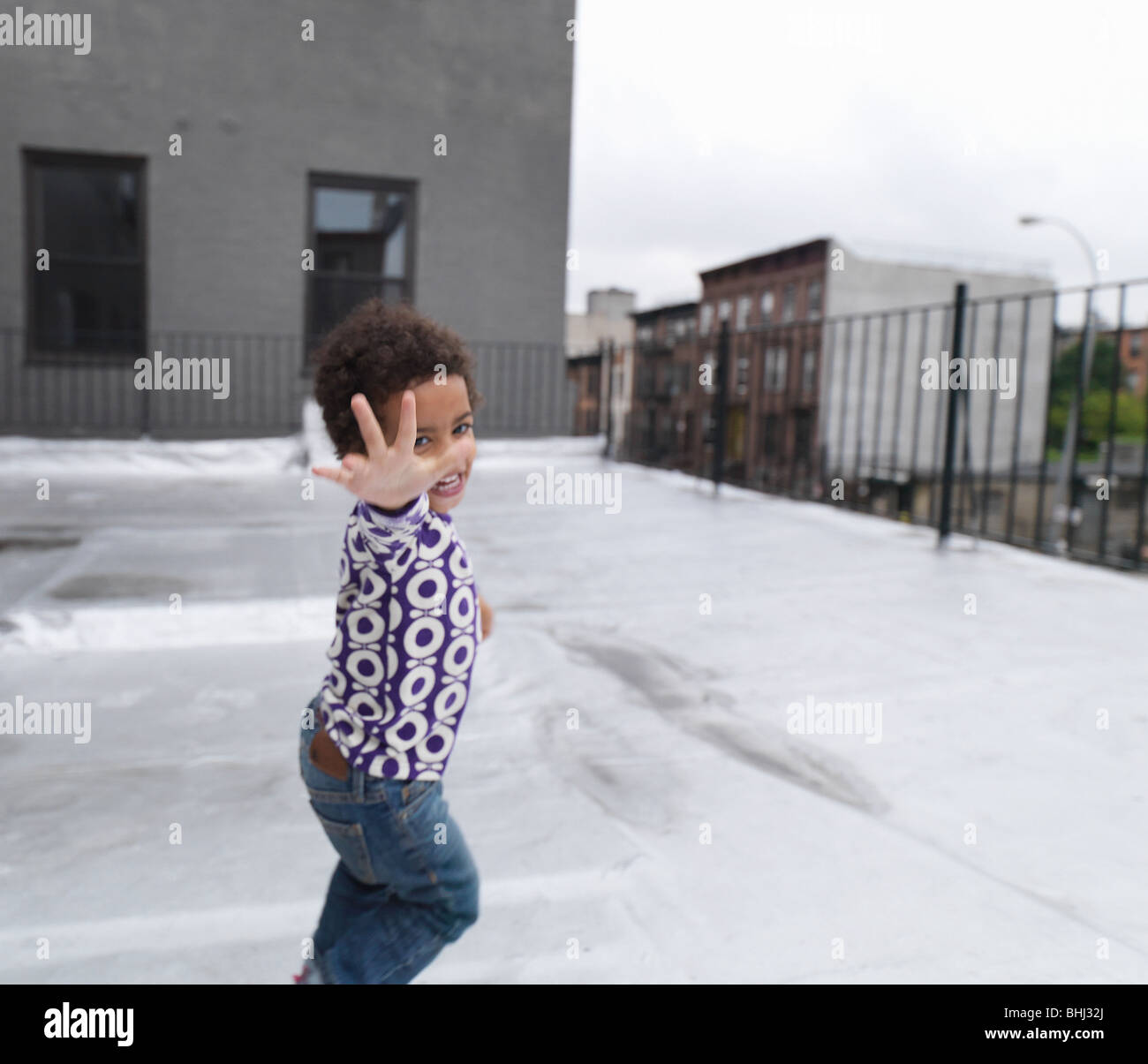 Girl running on roof terrace, smiling Stock Photo - Alamy