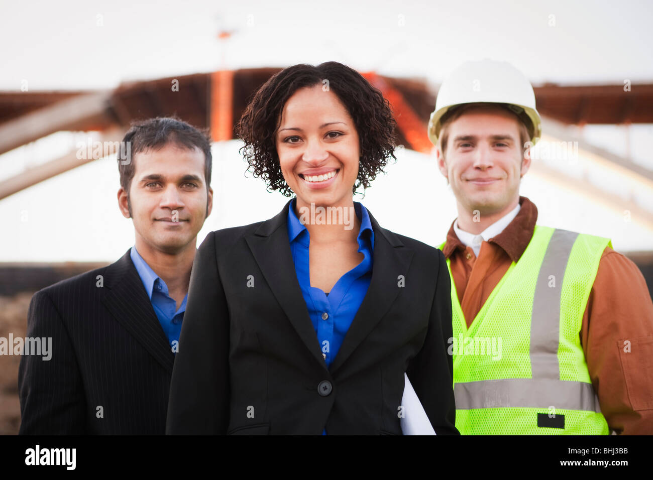 3 Engineers smiling on worksite Stock Photo - Alamy