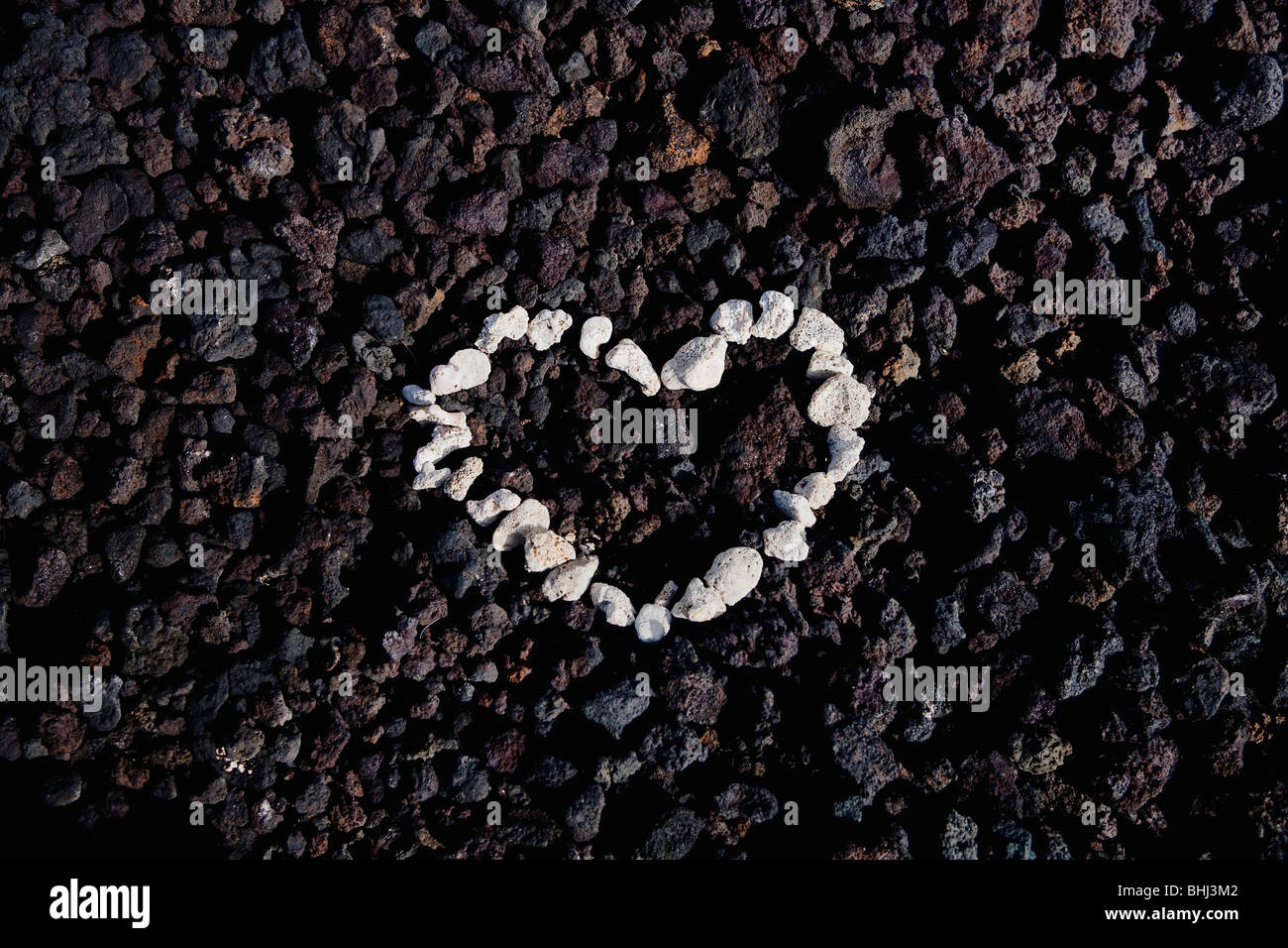 Heart made of white rock on black rock Stock Photo - Alamy