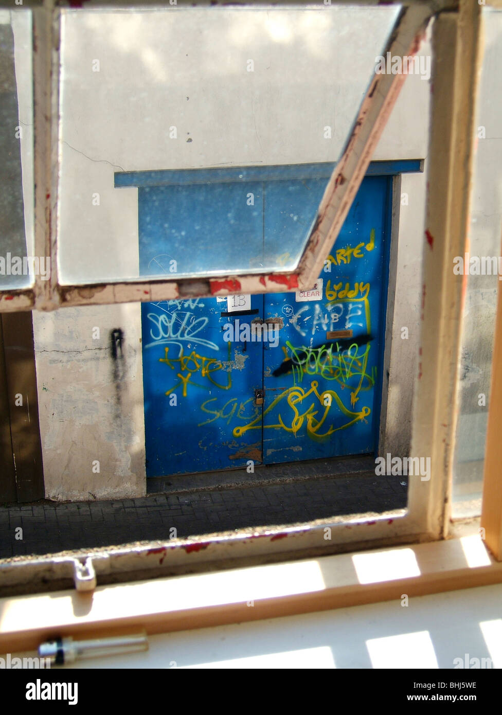 Open window with a view of a blue door on the street Stock Photo - Alamy
