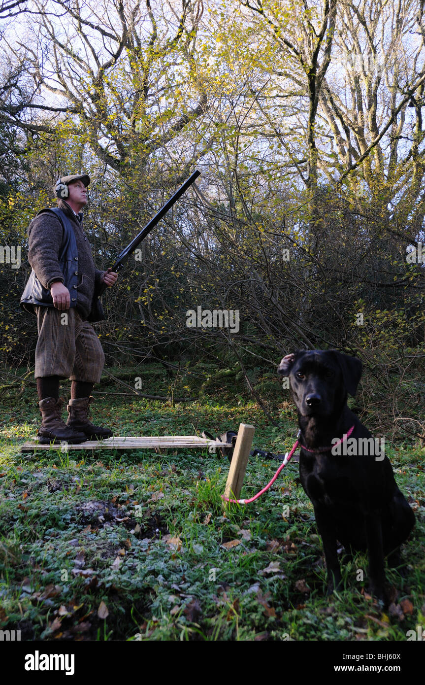 A man with a gun and a black labrador Stock Photo - Alamy