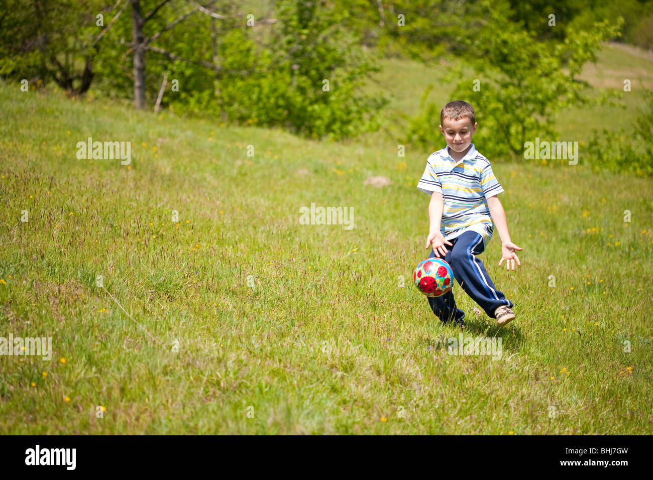 Cute boy playing football outdoor Stock Photo - Alamy