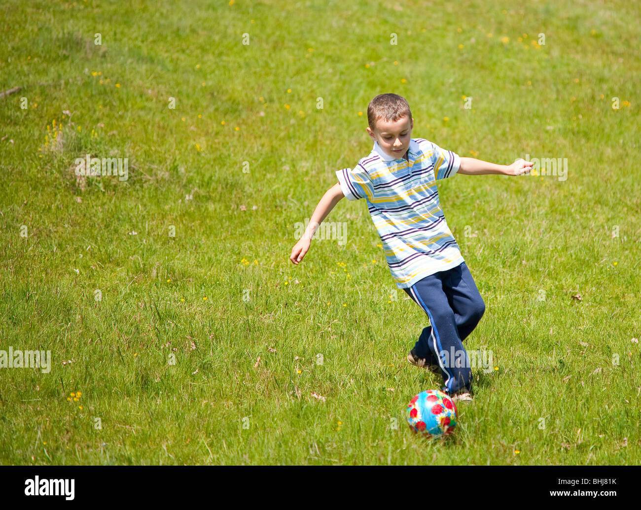 Cute boy playing football outdoor Stock Photo - Alamy
