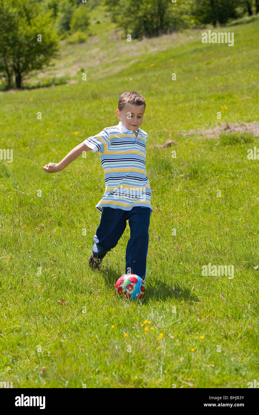 Cute boy playing football outdoor Stock Photo - Alamy