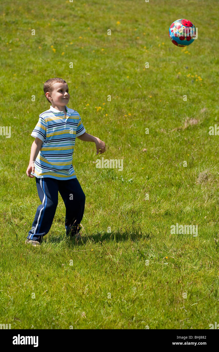 Cute boy playing football outdoor Stock Photo - Alamy