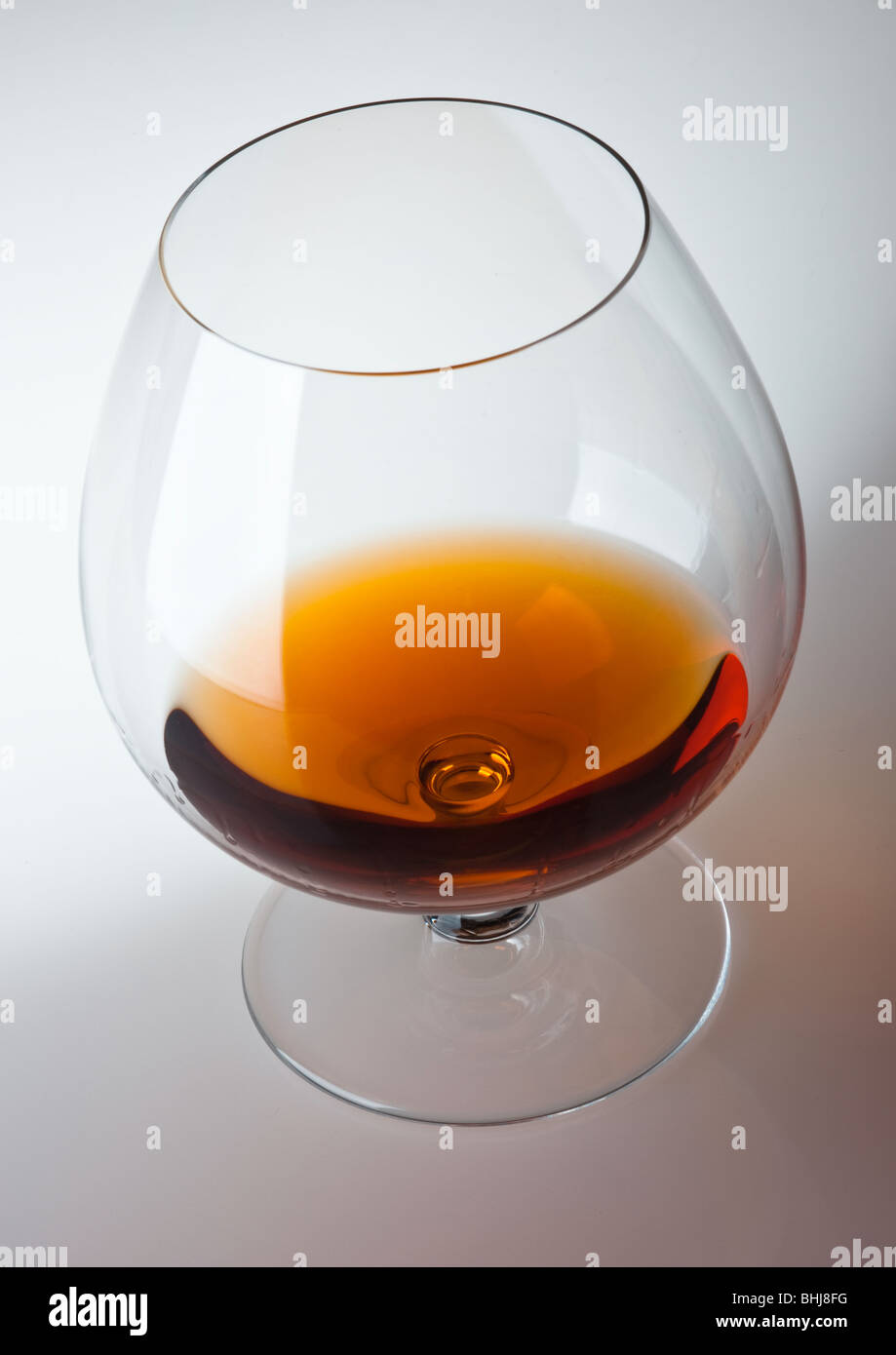 Glass with alcohol on a light background Stock Photo - Alamy