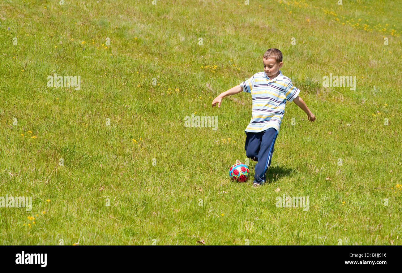 Cute boy playing football outdoor Stock Photo - Alamy