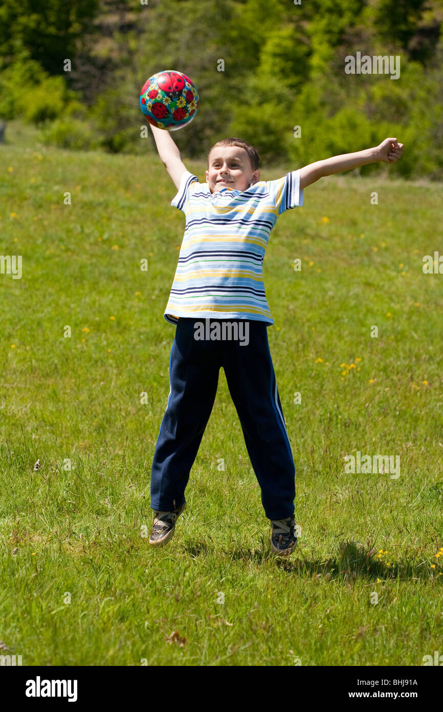 Cute boy playing football outdoor Stock Photo - Alamy
