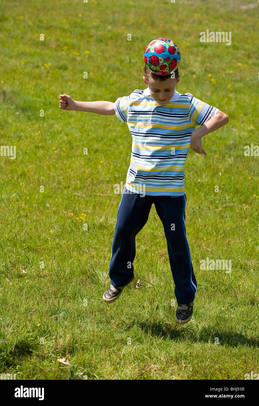Cute boy playing football outdoor Stock Photo - Alamy