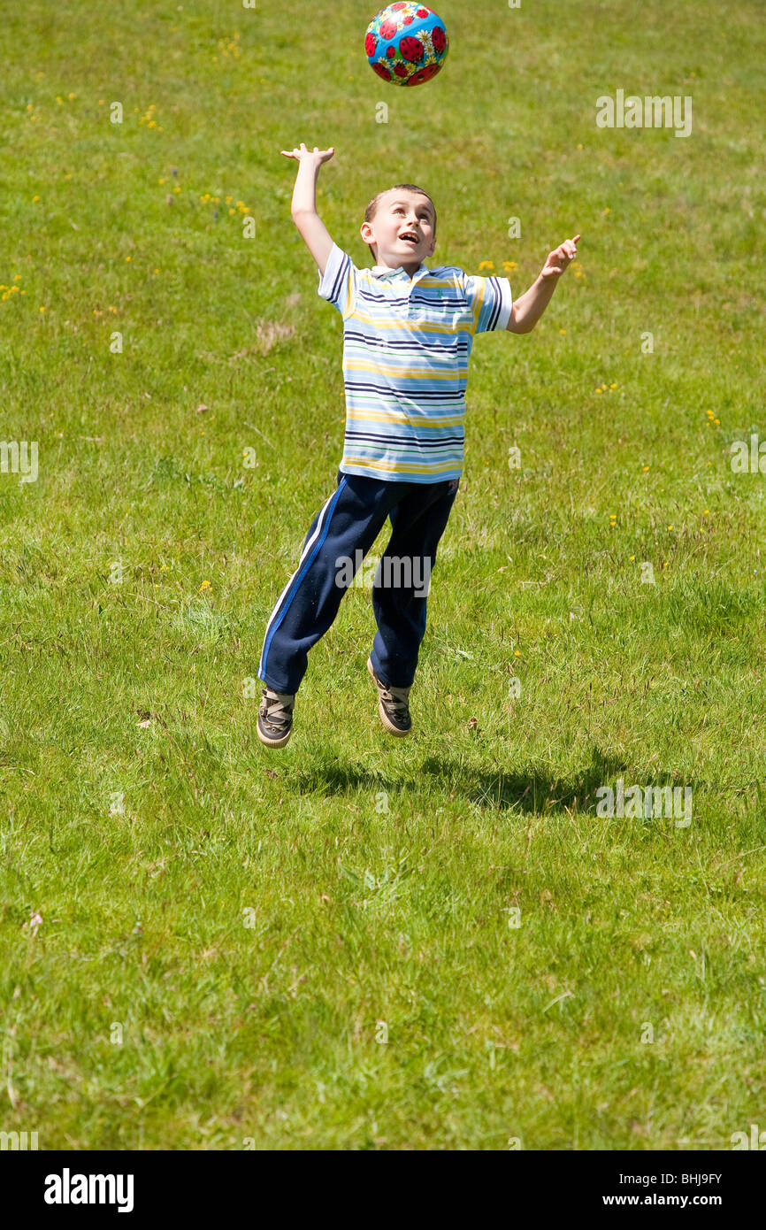 Cute boy playing football outdoor Stock Photo - Alamy