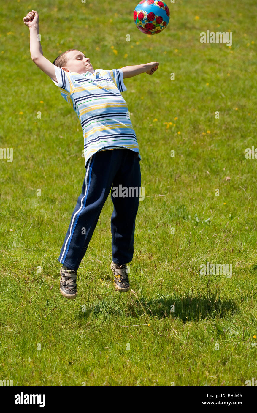 Cute boy playing football outdoor Stock Photo - Alamy