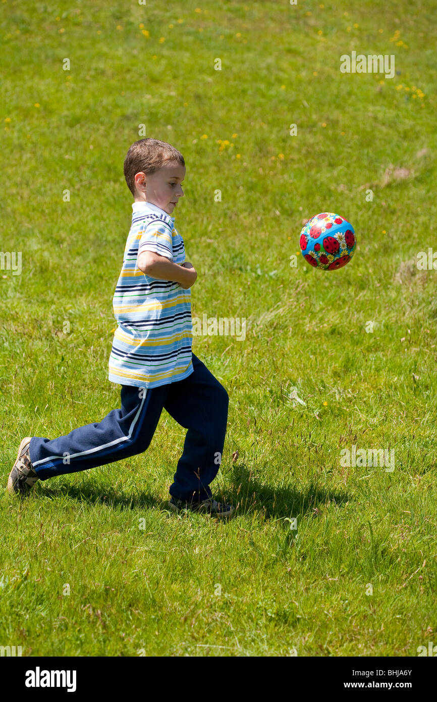 Cute boy playing football outdoor Stock Photo - Alamy
