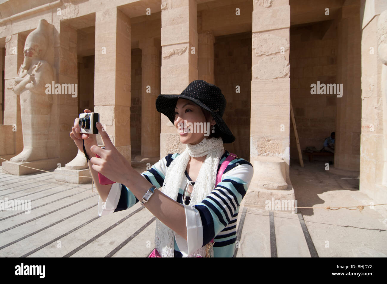 Pretty Japanese tourist takes a photograph at Hatshetsup Temple, Luxor ...