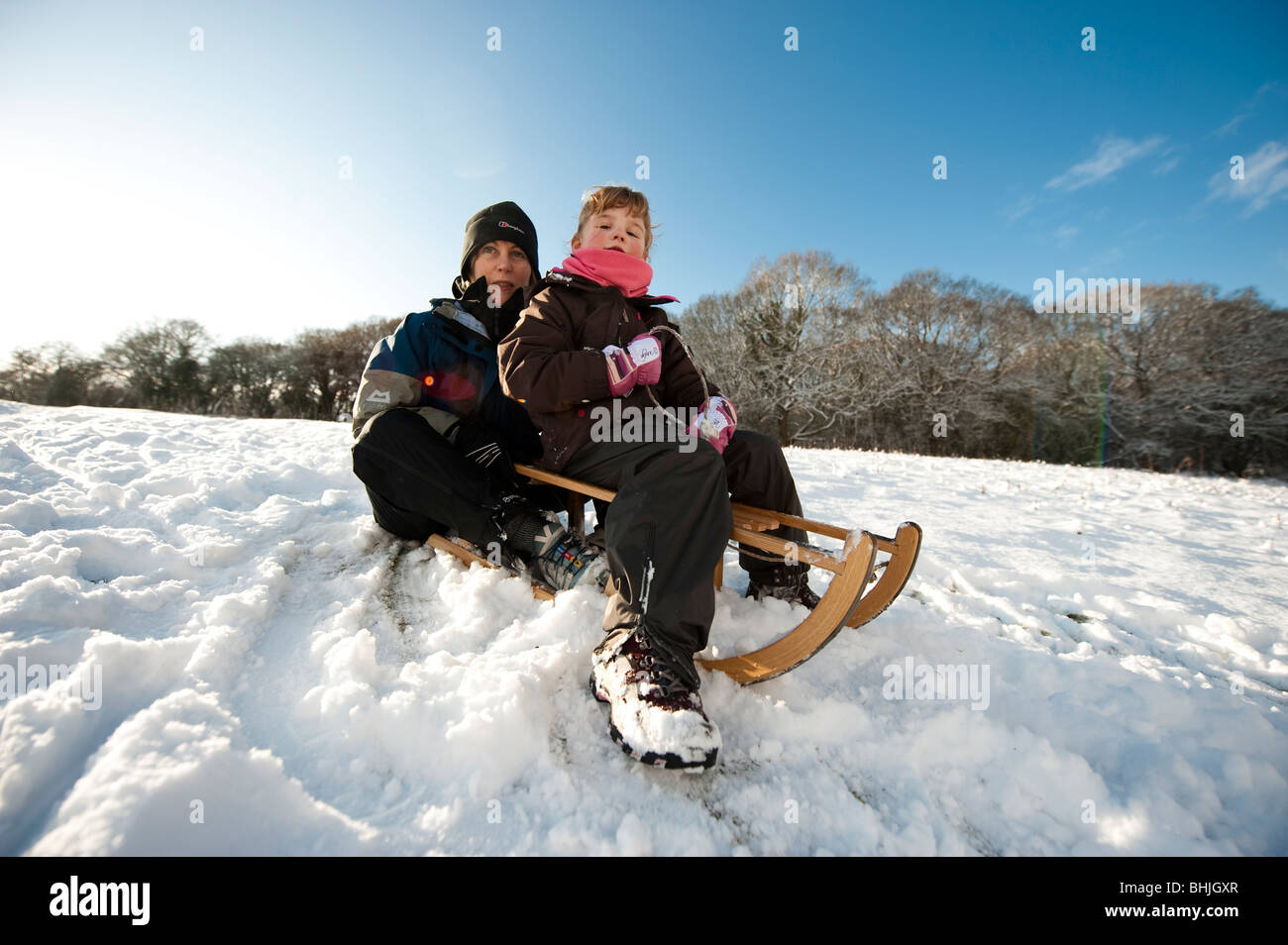 Mother and daughter on traditional Swiss made wooden sled Stock Photo ...