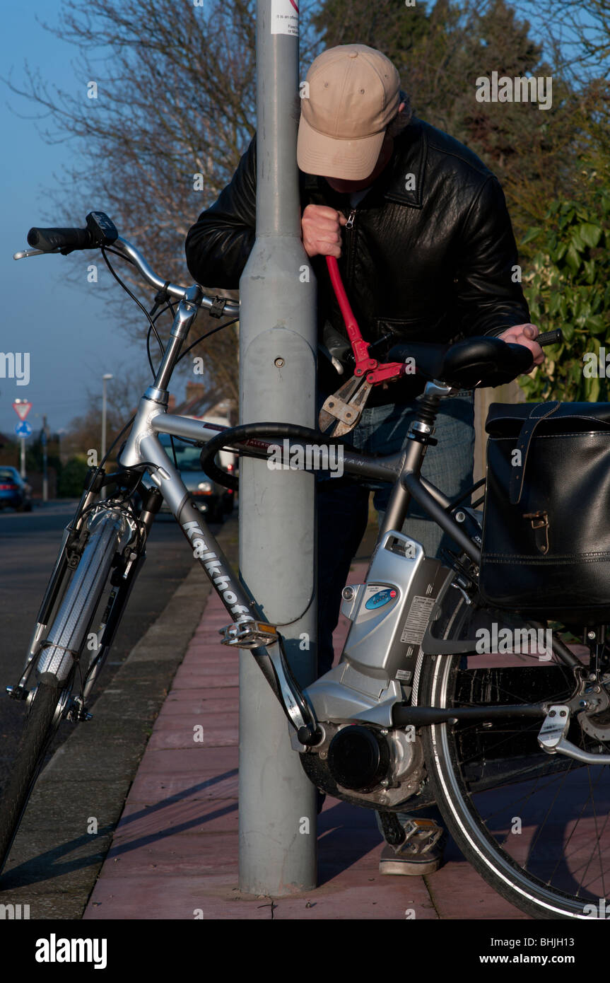 Bicycle thief takes wire cutters to steal chained up bike Stock Photo ...