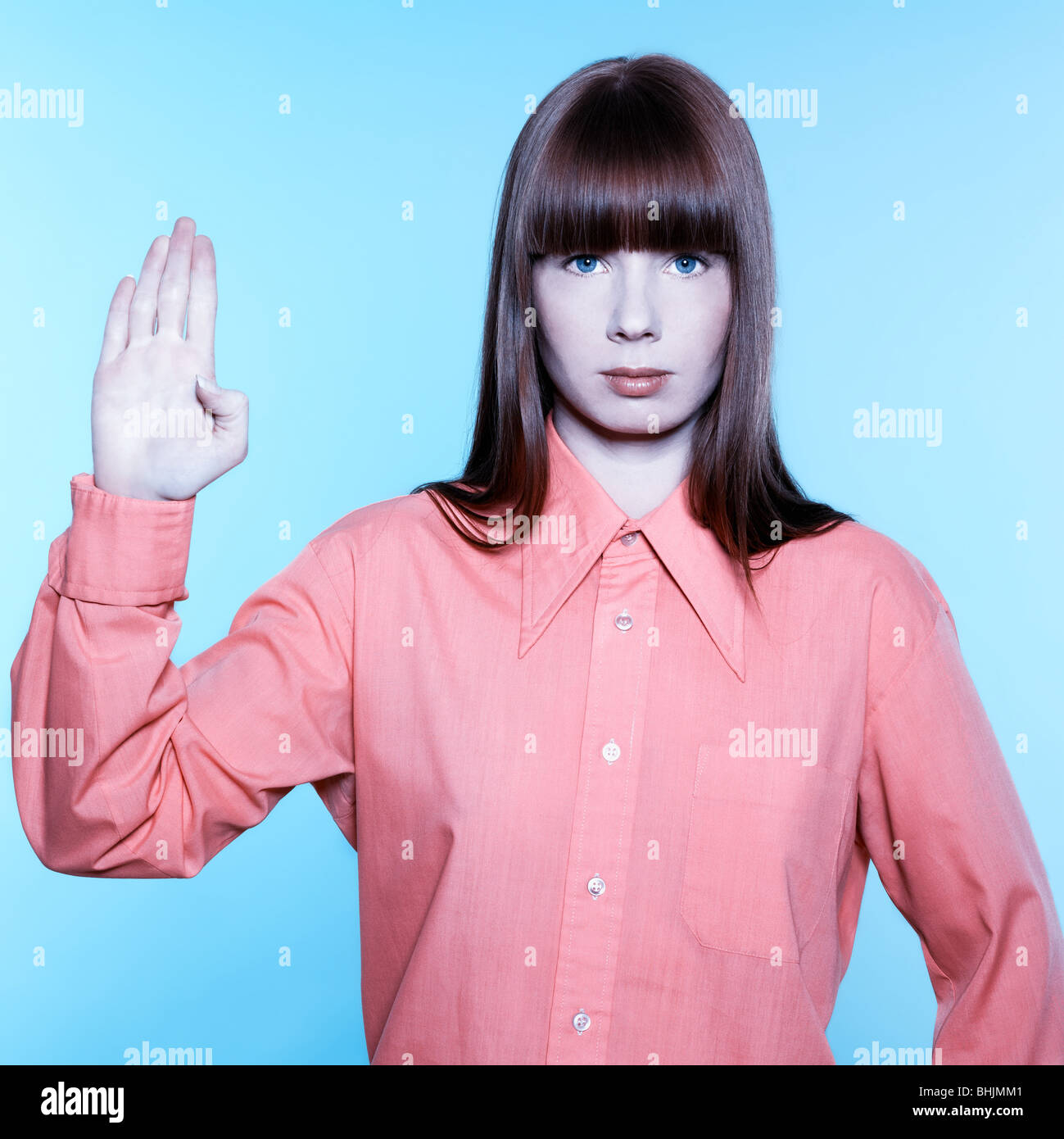 studio portrait of a young woman on isolated background gesturing sto ...