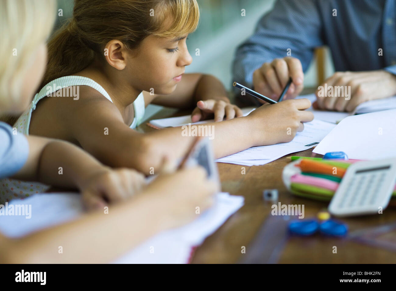 Student working on classwork, teacher helping Stock Photo - Alamy