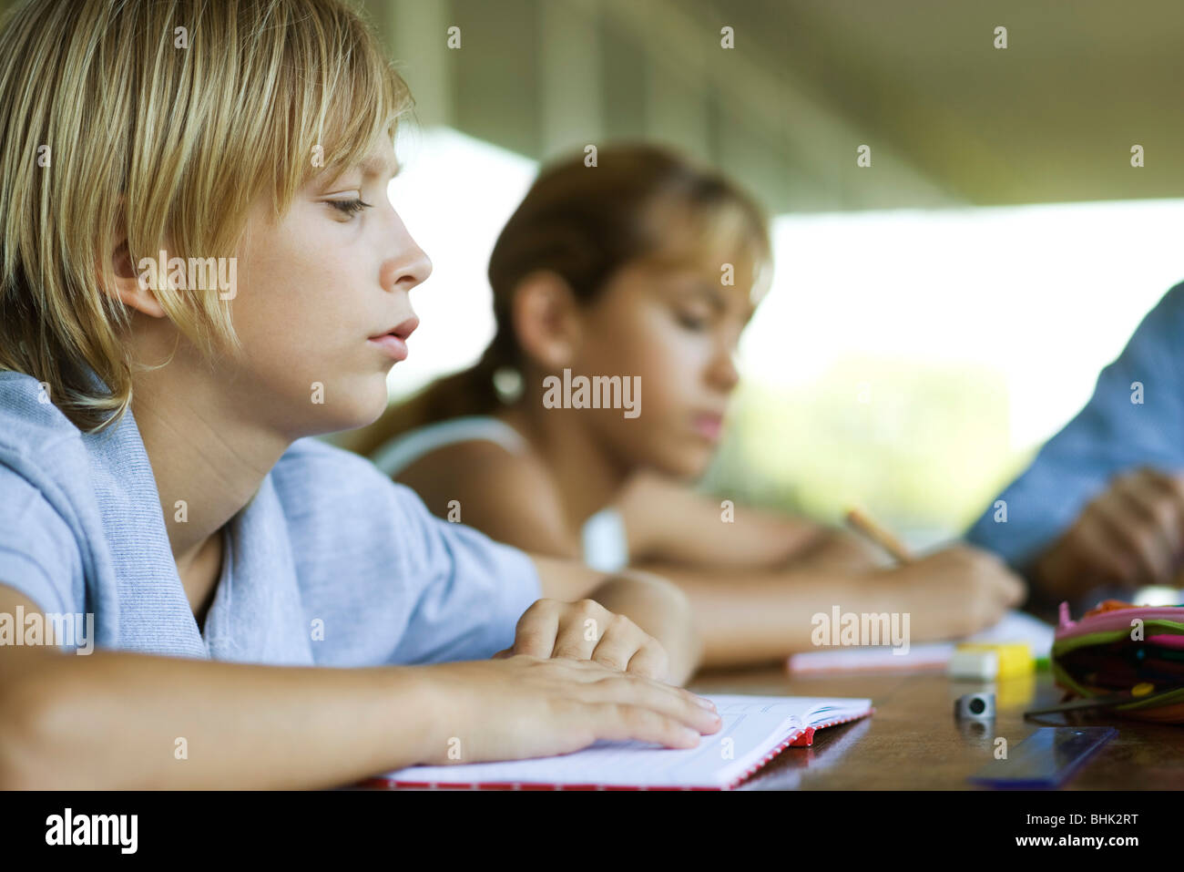 Student in class with book, looking away with boredom Stock Photo - Alamy